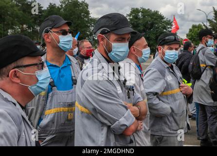 Renault workers wear protective face masks as they stage a protest ...