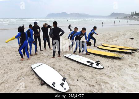 Children from "Waves Of Change" during a surfing lesson in Muizenburg ...