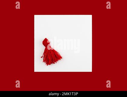 Rotes Baba-Marta-Symbol mit Quaste, Martenitsa auf weißer Karte. Der ...