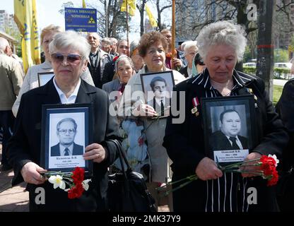 Widows of Chernobyl victims hold portraits of their husbands who died ...