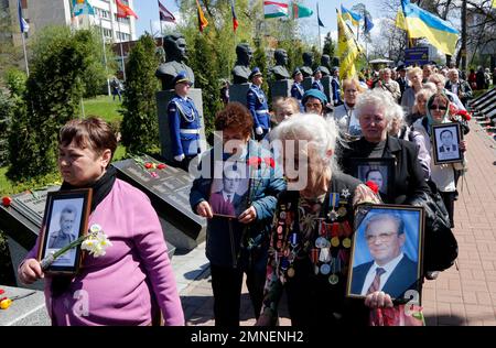 Widows of Chernobyl victims hold portraits of their husbands who died ...