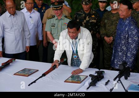 Philippine President Rodrigo Duterte checks the scope of a Chinese-made ...