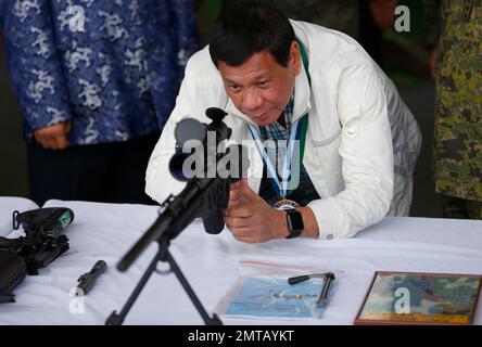Philippine President Rodrigo Duterte checks the scope of a Chinese-made ...