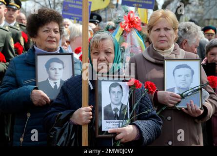 Widows of Chernobyl victims hold portraits of their husbands who died ...