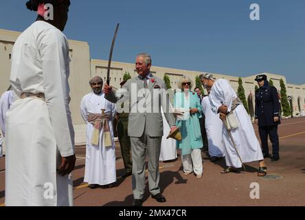 Britain's Prince Charles dances with a sword with a group of Omani ...