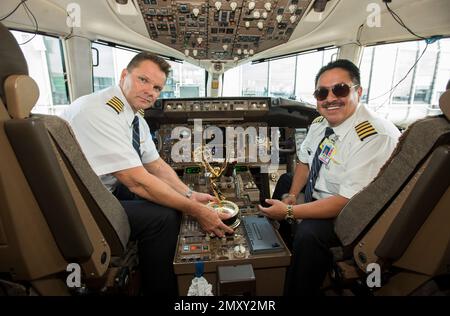 The United Airlines pilots pose in the cockpit with the Emmy statuette ...