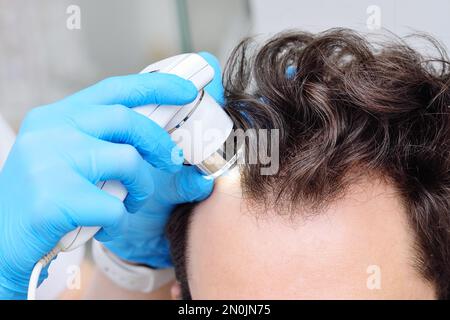 Der kosmetologische Trichologe in Nahaufnahme diagnostiziert den ...