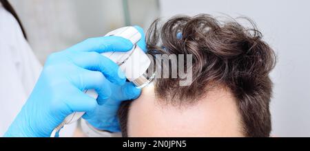 Der kosmetologische Trichologe in Nahaufnahme diagnostiziert den ...