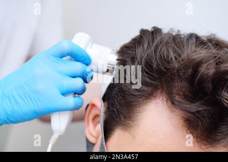 Der kosmetologische Trichologe in Nahaufnahme diagnostiziert den ...