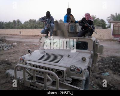 Iraqi soldiers sit in the back of a U.S. Marine humvee before a night ...