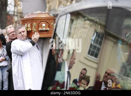 The coffin of Catholic Priest Alec Reid is driven along the Falls Road ...