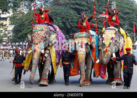 Mahouts ride decorated elephants as they pass in a procession through a ...
