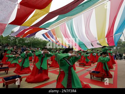 Girls wearing traditional dresses, bow during the 40th Coming of Age ...
