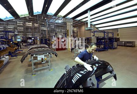 Assembler Christian Baumann transports a front car bumper during the ...
