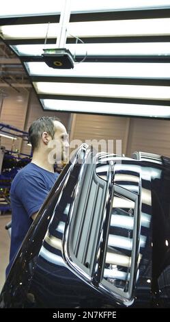 Assembler Christian Baumann transports a front car bumper during the ...