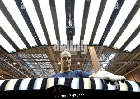 Assembler Christian Baumann transports a front car bumper during the ...