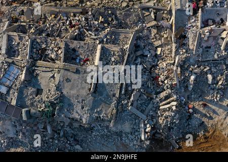Rescue workers continue to clear rubble from collapsed houses in ...