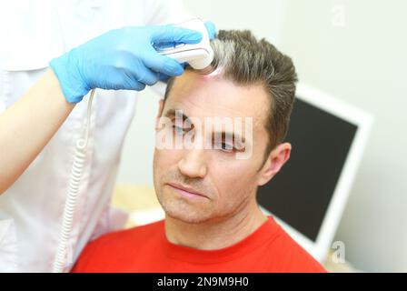 Ein Kosmetologe-Trichologe diagnostiziert den Zustand des Haares eines ...