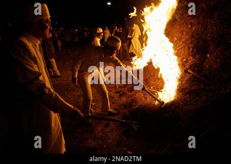An Iranian Zoroastrian priest sets fire to a prepared pile of wood in a ...