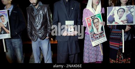 Supporters of Pakistan's slain leader Benazir Bhutto hold posters of ...