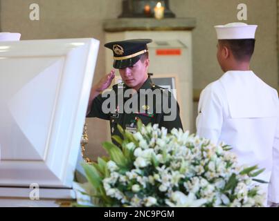 A Philippine military officer salutes to pay his last respects to ...