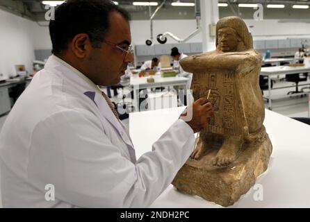An Egyptian archeological technician works at a pharonic falcon mummy ...