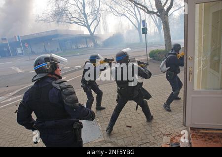 Riot police officers approach anti-NATO activists who set fire to an ...