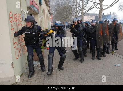 Riot police officers approach anti-NATO activists who set fire to an ...