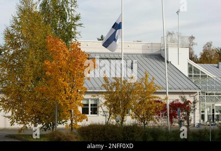 The Finnish flag flies half staff outside Jokela school, rear, in ...