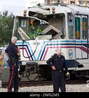 Police and transit workers investigate the scene of a Light Rapid ...