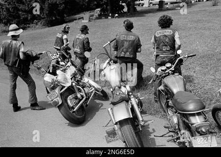 Members of the Pagans motorcycle gang wait for a priest to conclude ...