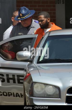 Willie Cory Godbolt, right, escorted by a lawman, looks around the ...