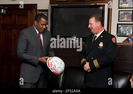 U.S. Rep. Kendrick Meek receives a signed fire fighter helmet from ...