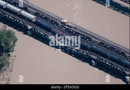 Crews work at the scene of a rail bridge collapse and railcars ...
