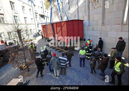 Firemen use a crane to lift a WWII cattle car to put it in its place ...