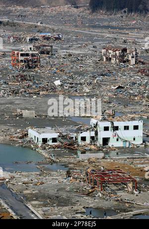 Rubble is scattered across the wide areas of the town of Minami Sanriku ...