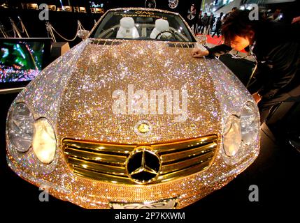 Japanese automotive accessories company D.A.D staff Ryota Mizoguchi checks a Mercedes Benz SL 600 covered by Swarovski s 300 000 gold shadow crystal pieces designed by D.A.D at Makuhari Messe in Chiba...