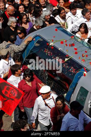 People accompany the car carrying the coffin of Chile's late folk ...