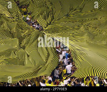 Saudi Al Ittihad soccer fans wave a flag with the name their new team ...