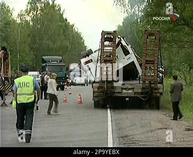 The wreckage of a bus atop a trailer is seen at the site of a traffic ...