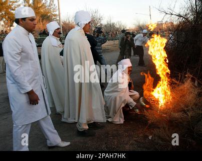 An Iranian Zoroastrian priest sets fire to a prepared pile of wood in a ...