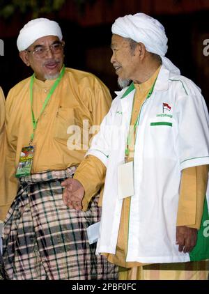 Opposition spiritual leader Nik Aziz Nik Mat, center, is greeted by ...