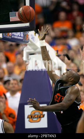 Oklahoma State forward Mario Boggan, left, deflects a shot by Mercer ...