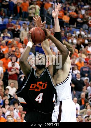Oklahoma State forward Mario Boggan, left, deflects a shot by Mercer ...