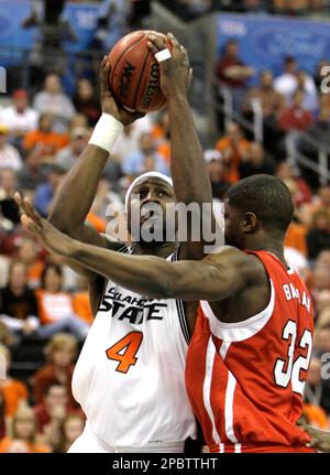 Oklahoma State forward Mario Boggan, left, deflects a shot by Mercer ...
