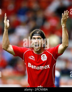 Toluca's soccer player Bruno Marioni, top, from Argentina kicks the ...