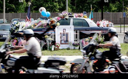 Two Fairfax County, Va. police officer ride their motorcycles past the ...