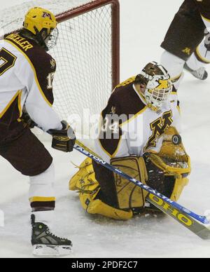 Minnesota goalie Kellen Briggs (34) eyes the puck as it slides through ...