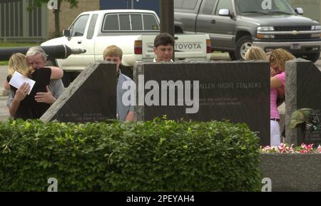 Family members of Army Spc. Robert Lund grieve while placing flowers on ...