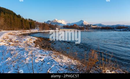 Abendrot mit einem hellen Sonnenstrahl über den verschneiten Bergen von ...